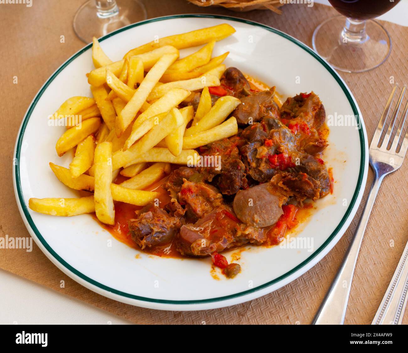 Chicken gizzards in vegetables salsa with fried potatoes Stock Photo ...