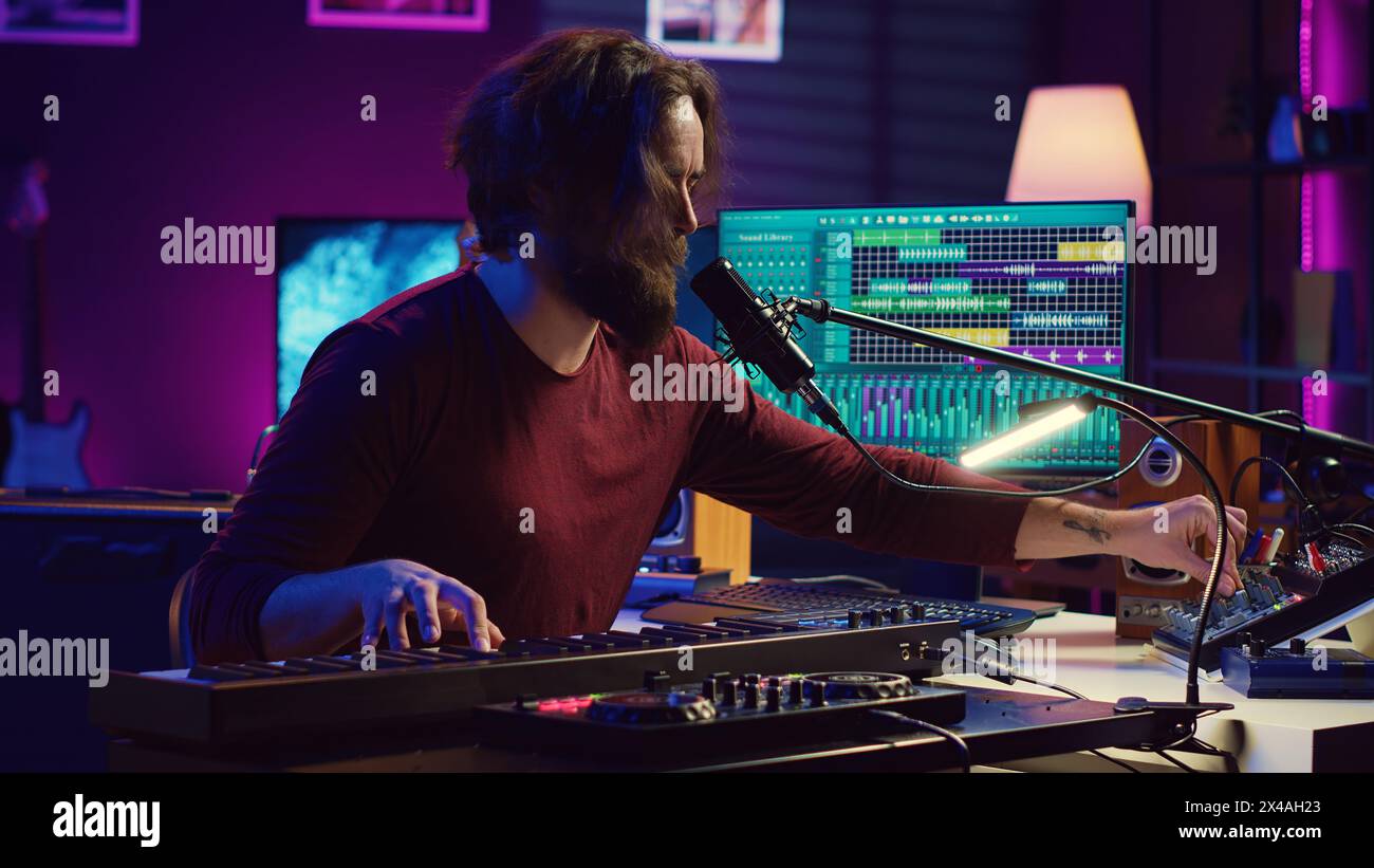 Skilled musician composing a song on piano midi controller, working ...