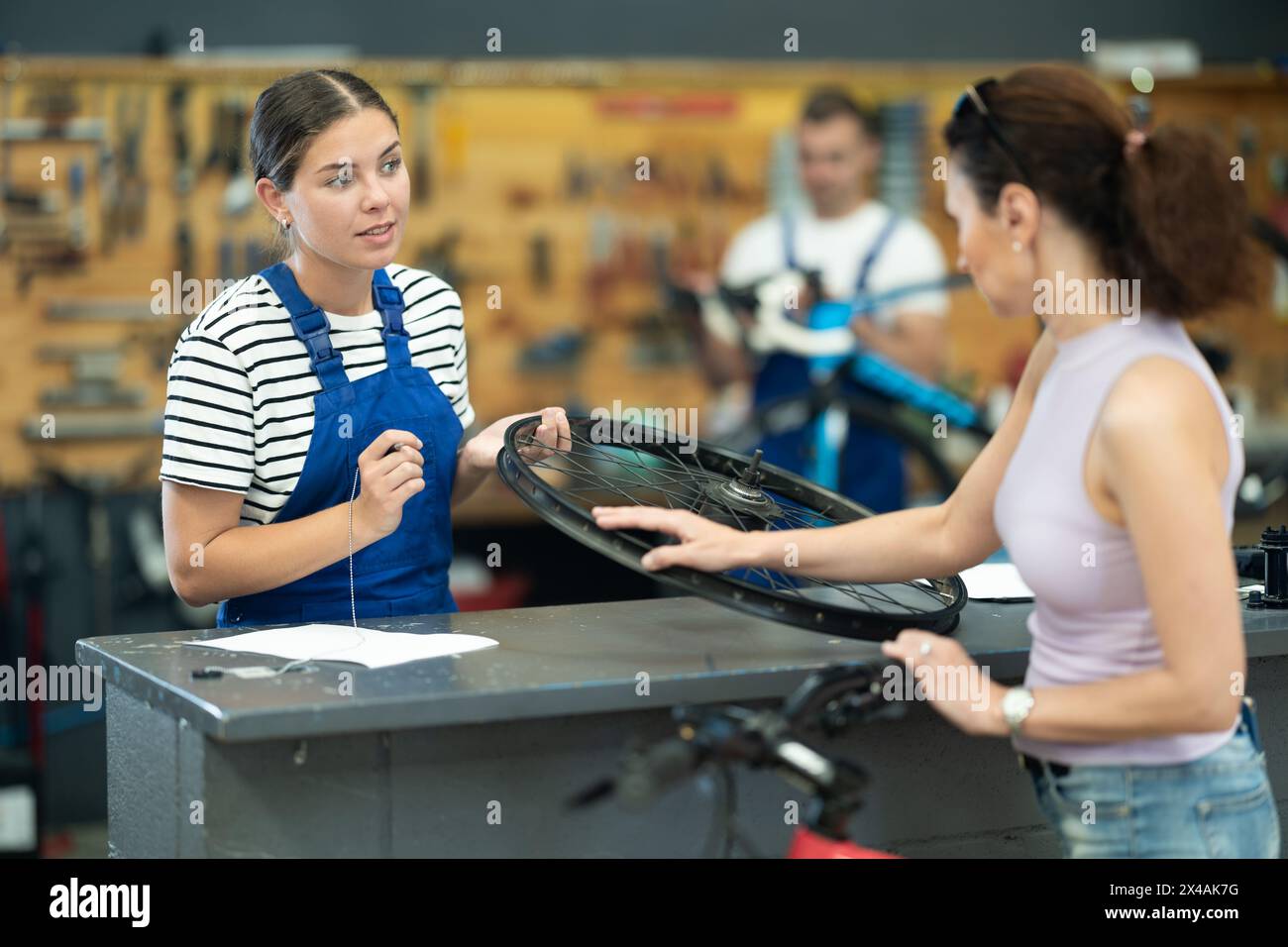 Female bike mechanic filling out order form during customer consultation Stock Photo - Alamy