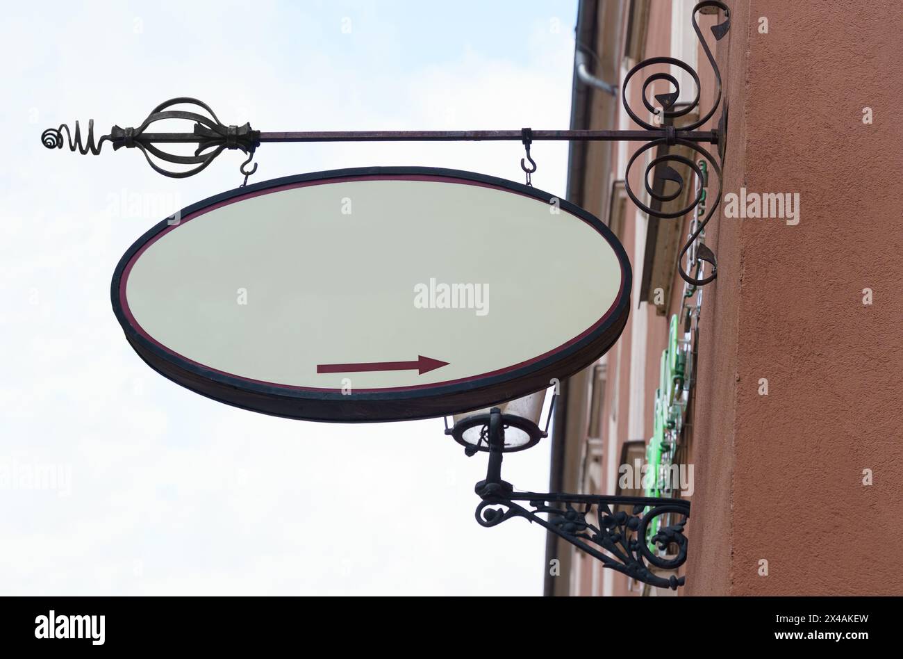 An oval signboard with a blank space for mockups is hanging from a ...