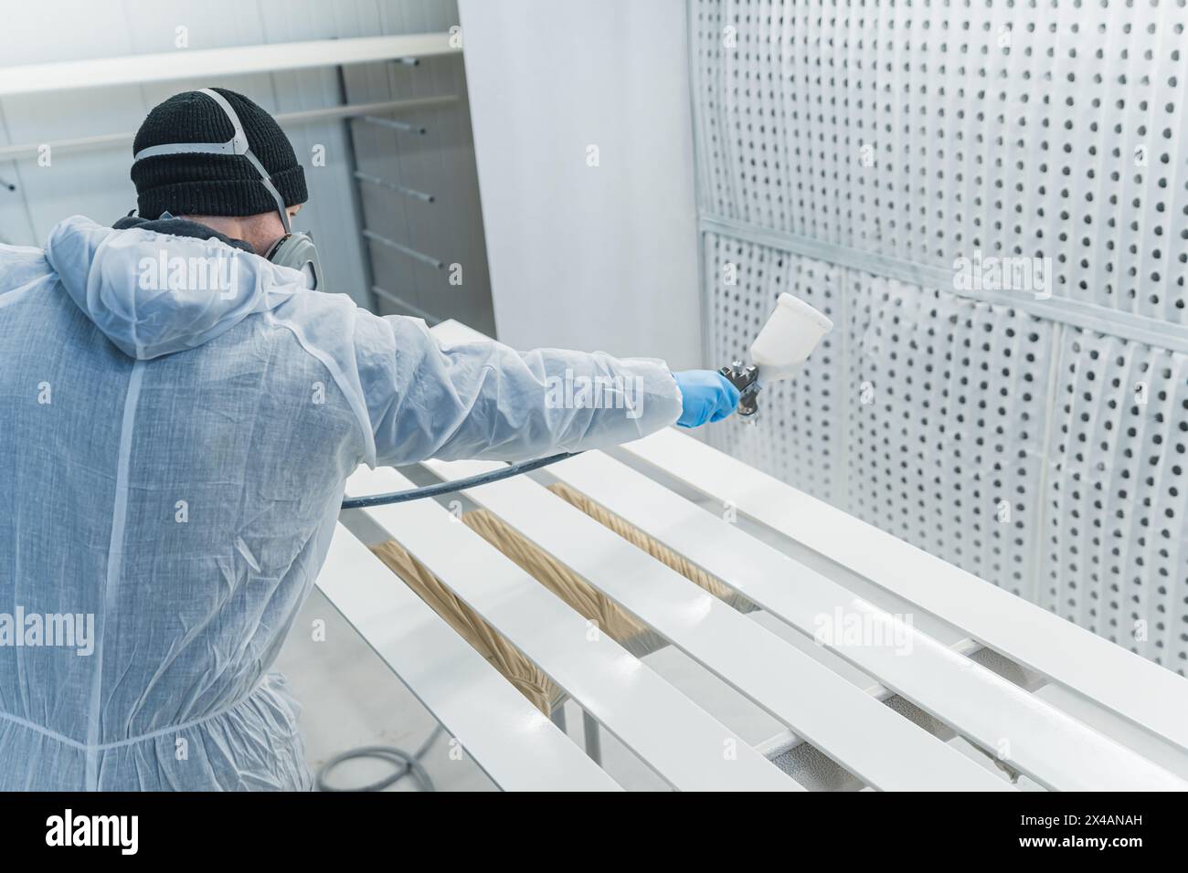 worker using spray gun and painting wood. Application of flame ...