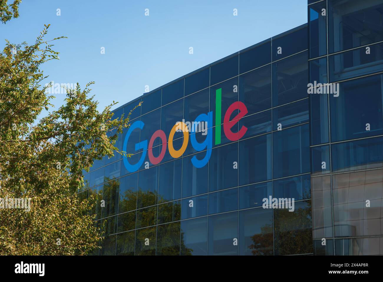 Modern building displays colorful Google logo, glass facade, clear sky ...