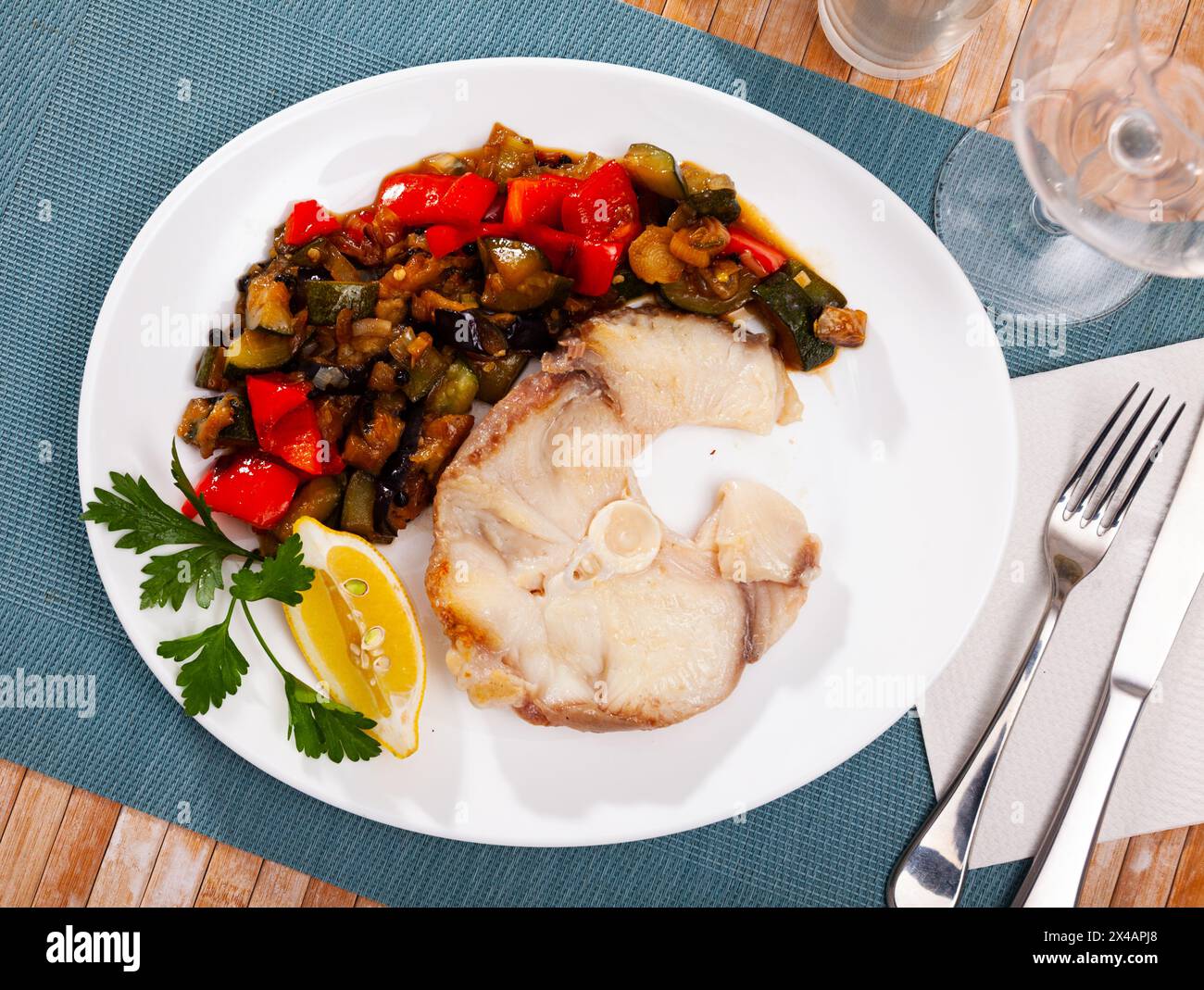 Baked steak of shark with stewed vegetables and lemon Stock Photo - Alamy