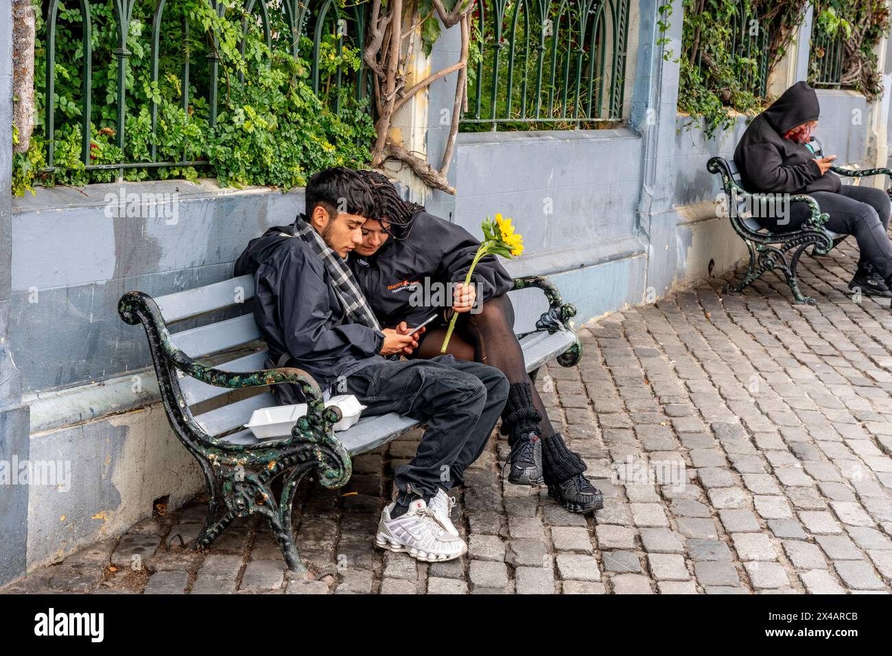 Two Young People Sitting On A Bench In The Historic Quarter Of ...