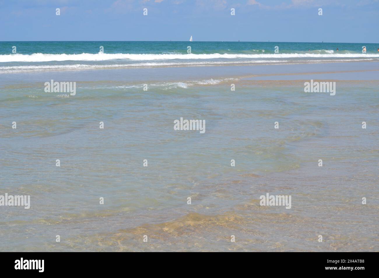 A beach backdrop featuring rippling and crashing waves, the expansive ...