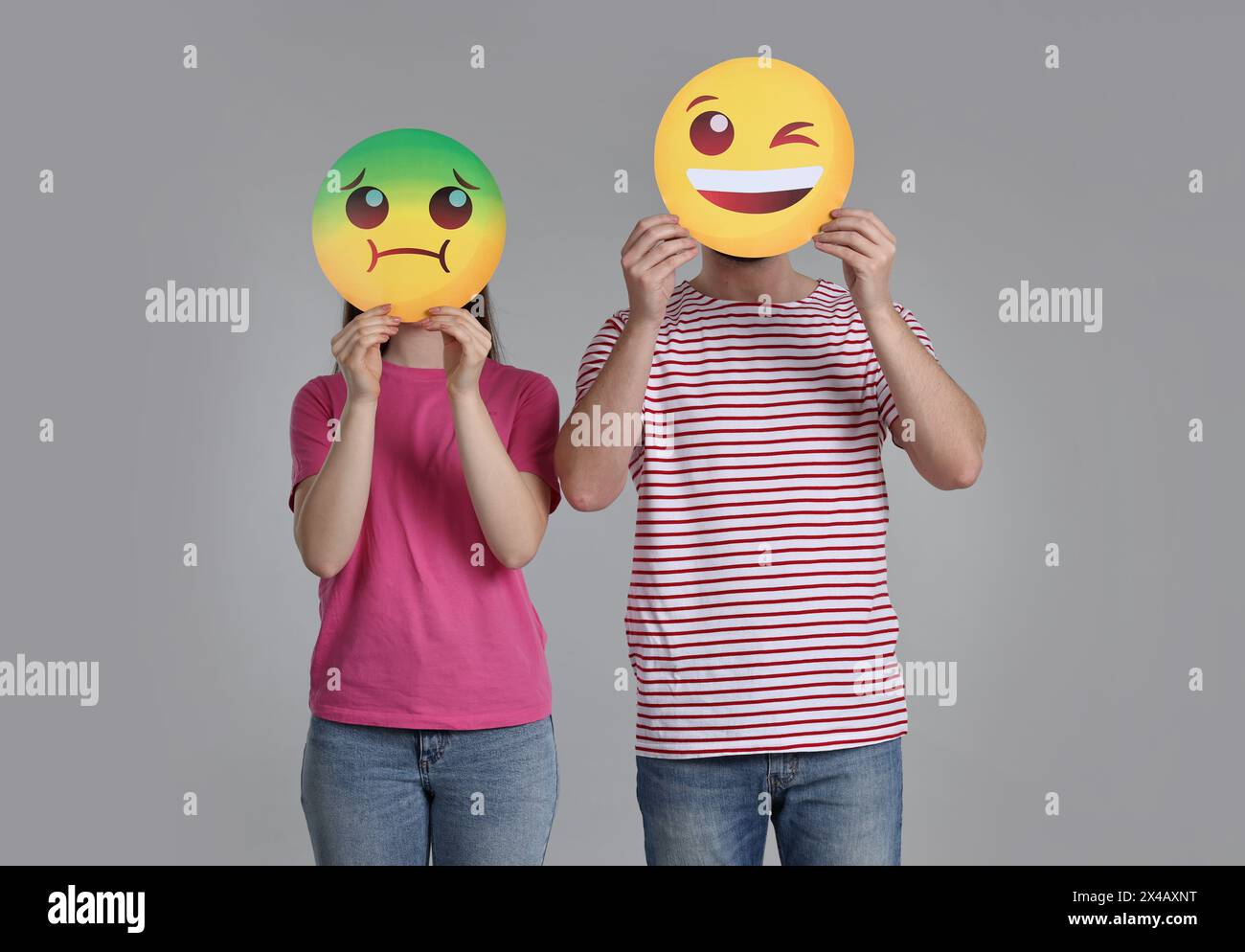 People covering faces with emoticons on grey background Stock Photo - Alamy