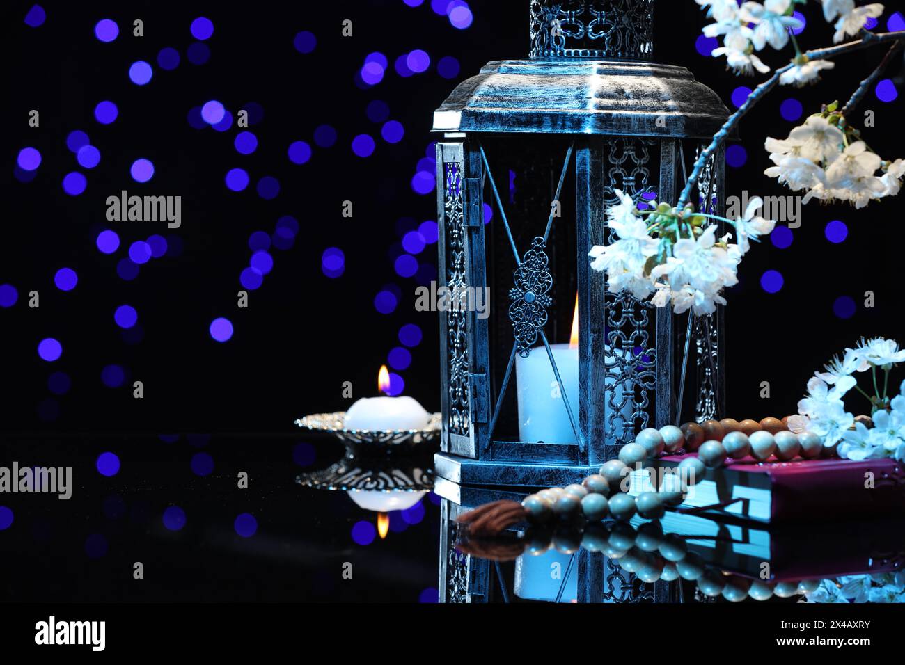 Arabic lantern, Quran, misbaha, burning candle and flowers on mirror ...