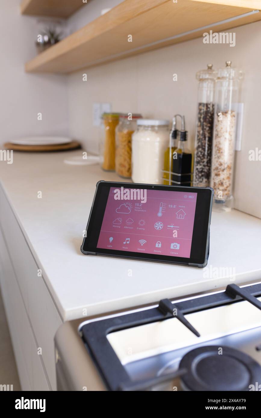 A tablet displaying smart home interface rests on a kitchen counter at ...