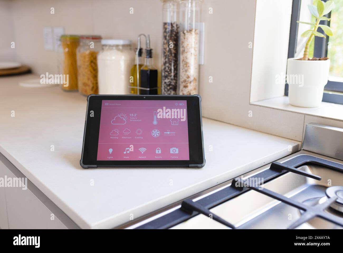 A tablet displaying smart home interface rests on a kitchen counter at ...