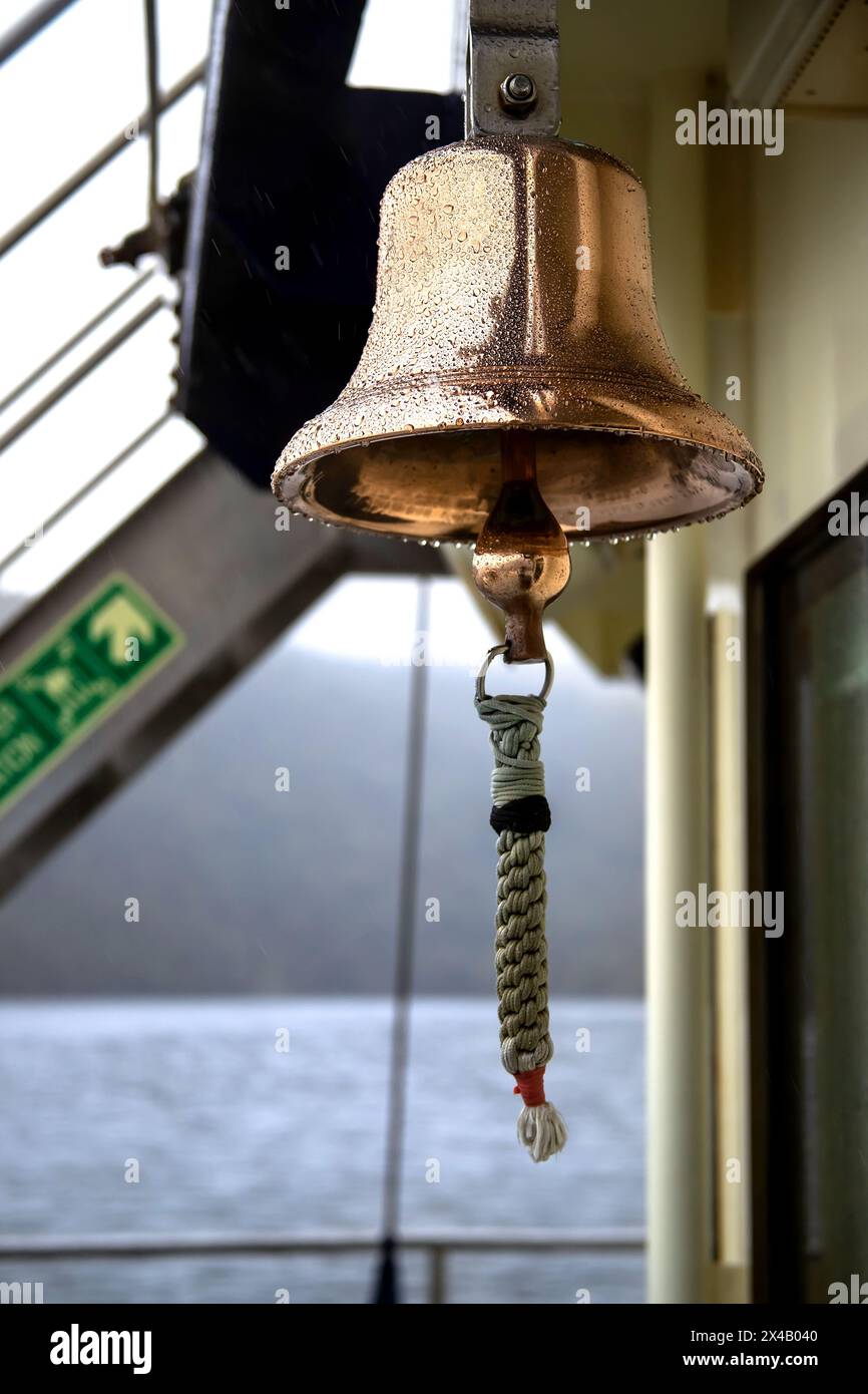 Copper ship bell adorned with raindrops: a vintage symbol of maritime ...