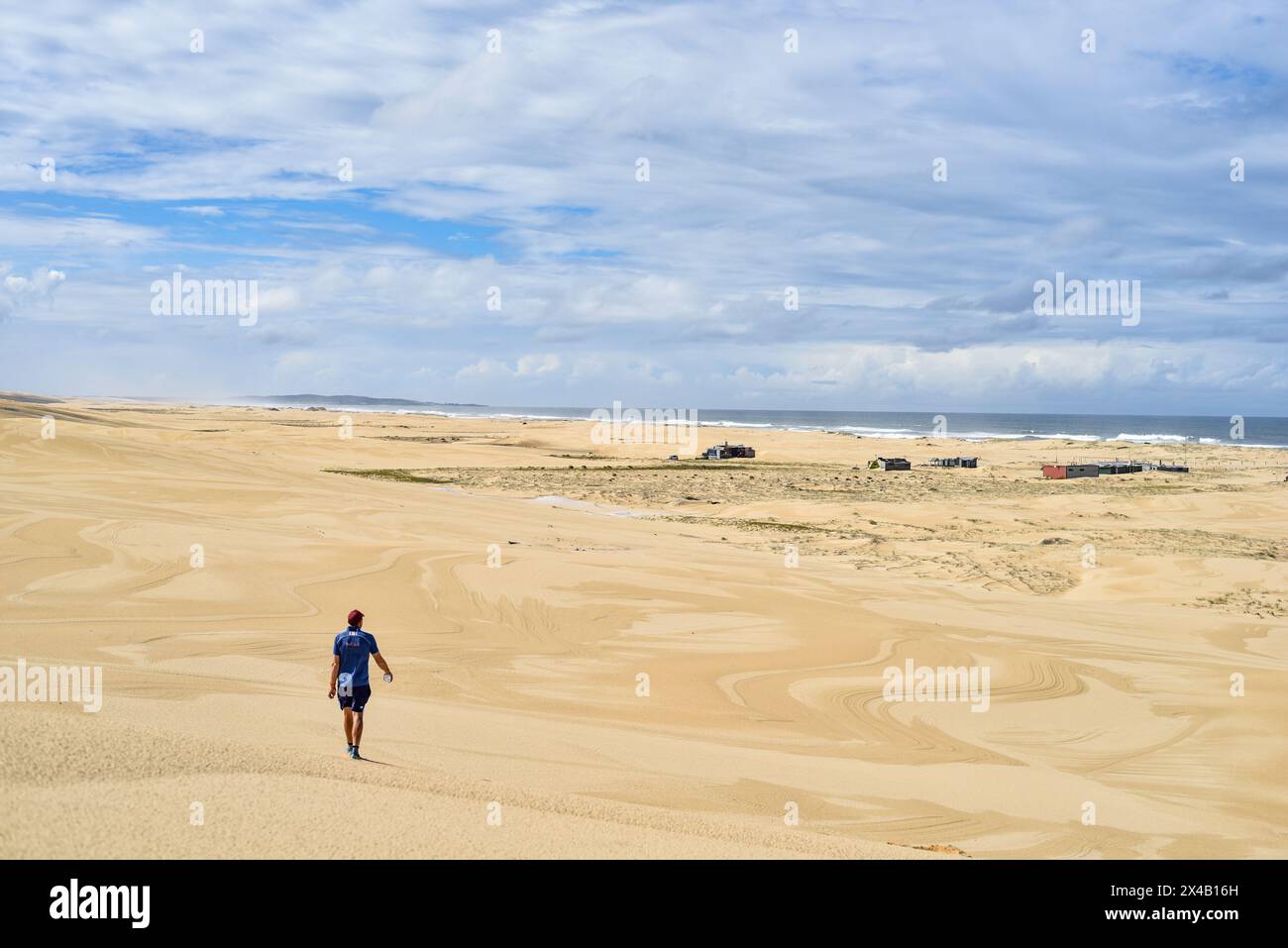 man walking through vast sand dunes Stock Photo - Alamy