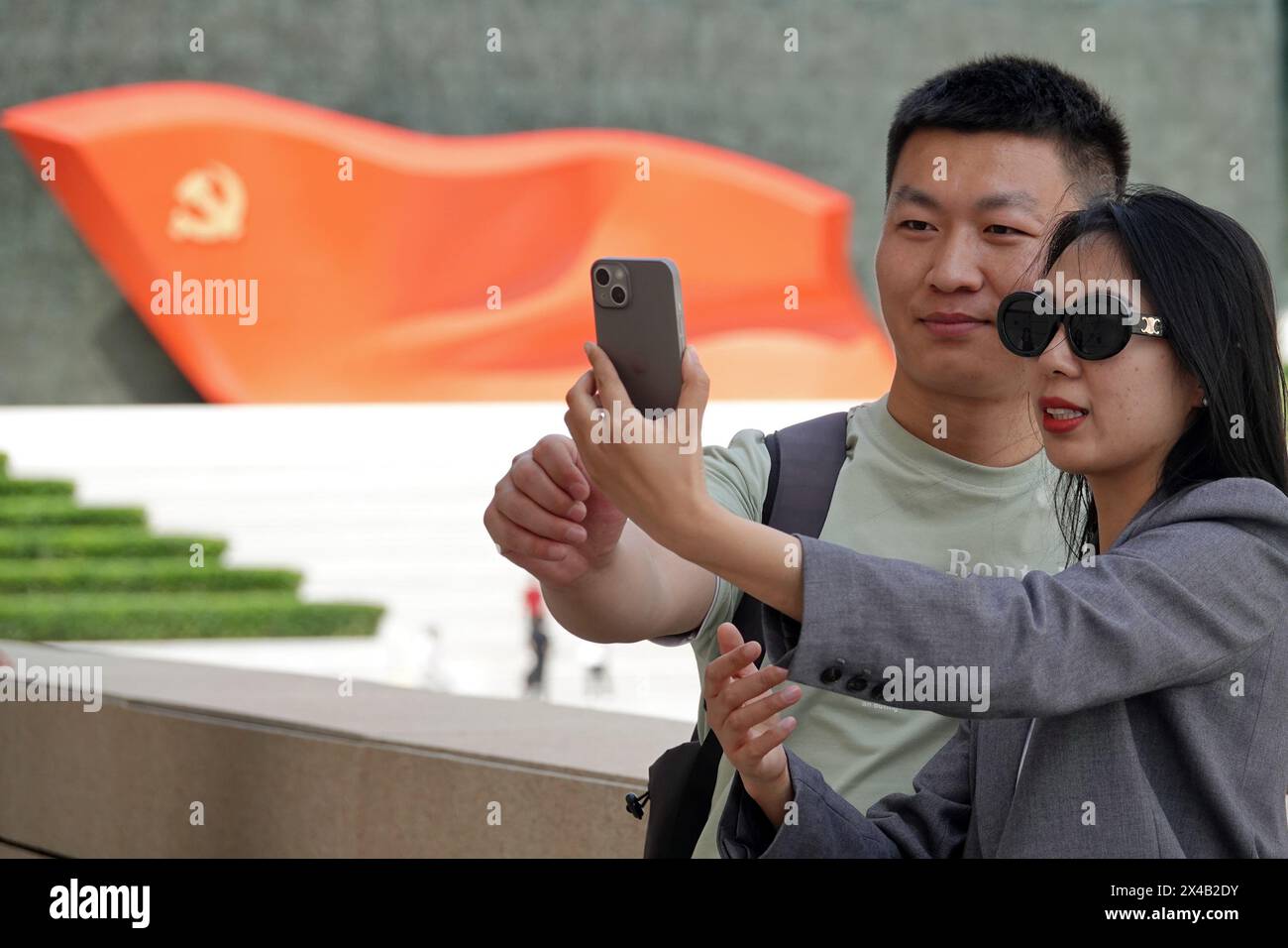 BEIJING, CHINA - MAY 1, 2024 - Visitors pose with party flags at the ...