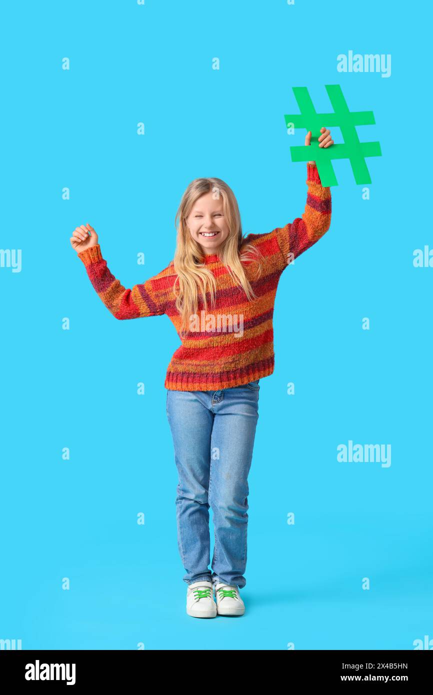 Cute teenage girl with hashtag on blue background Stock Photo - Alamy