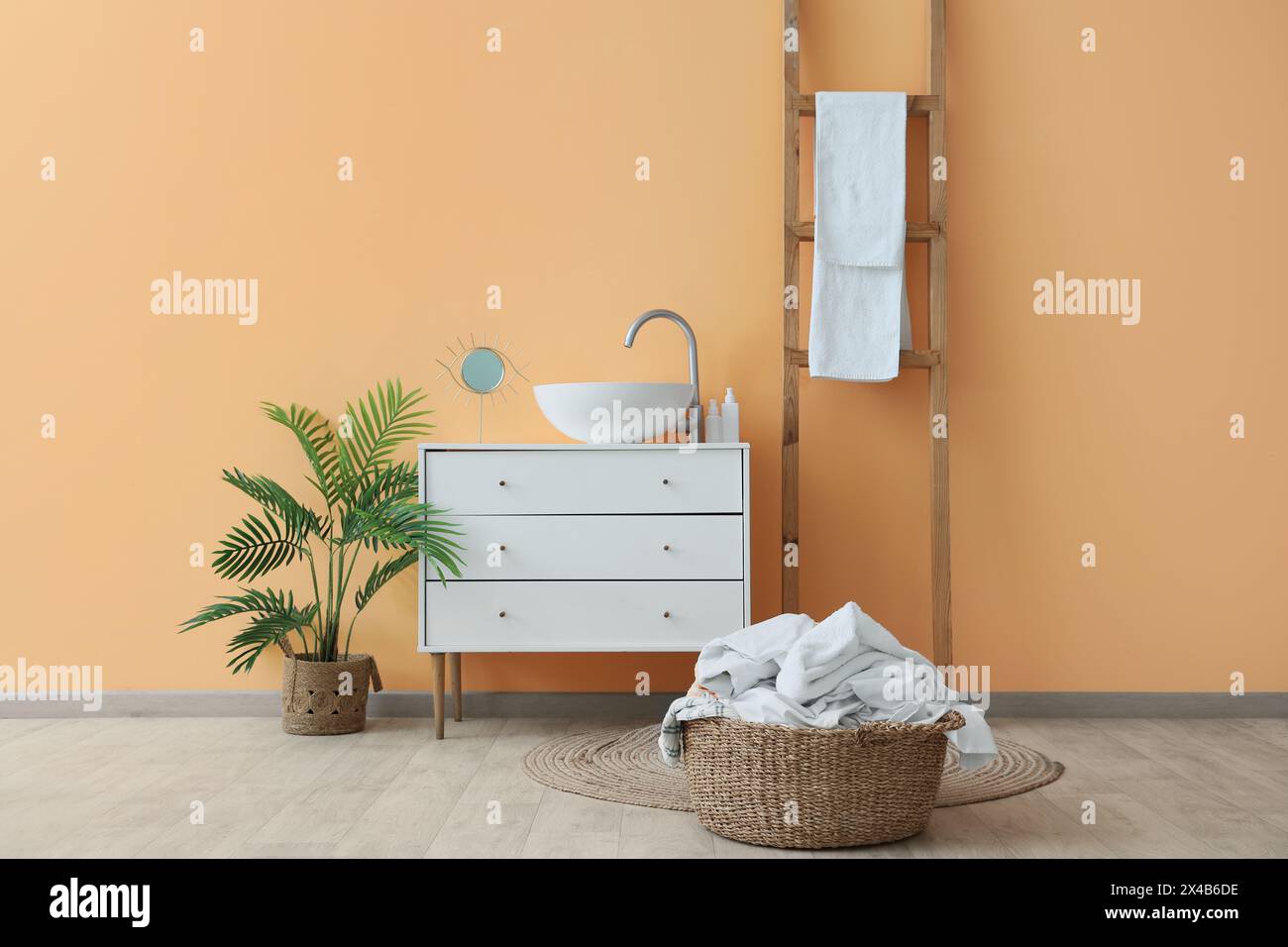 Interior of laundry room with basket, ladder and sink Stock Photo - Alamy