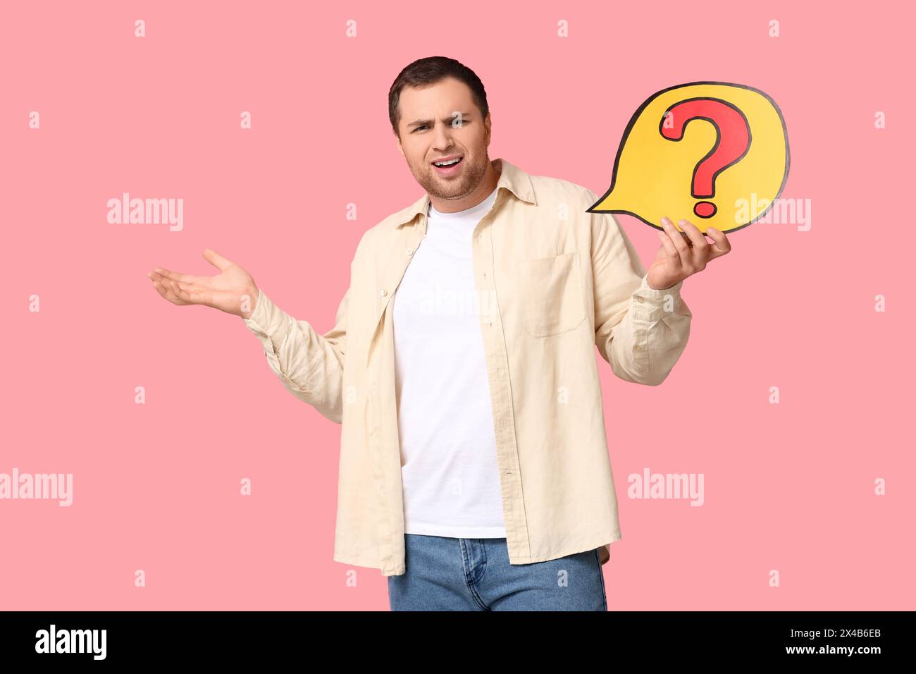 Confused young man with question mark on pink background Stock Photo ...