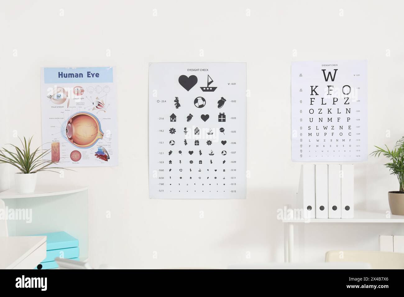Eye test charts on light wall at oculist's office Stock Photo - Alamy