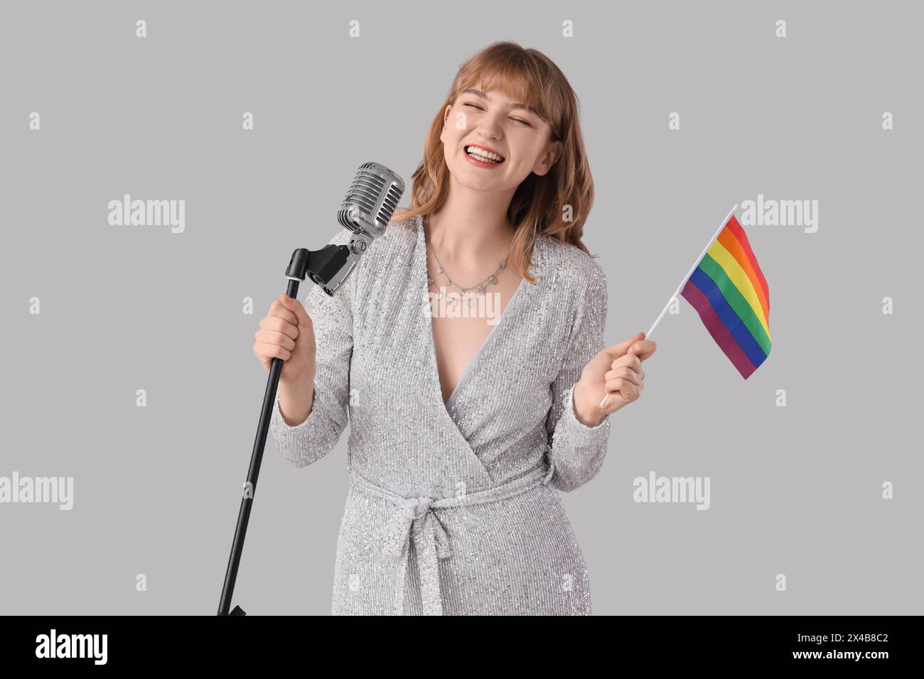 Female singer with LGBT flag and microphone on light background Stock ...