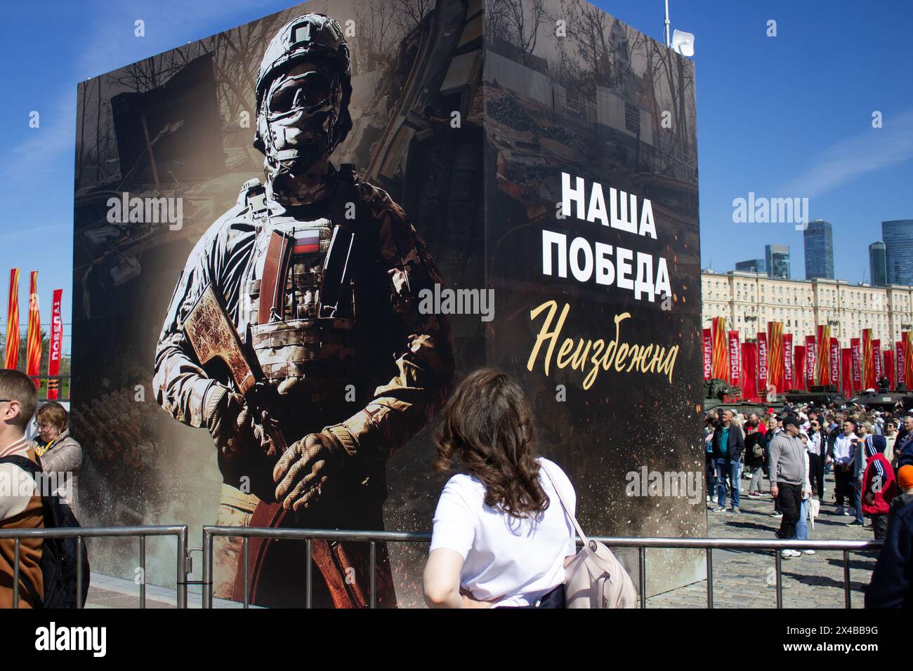 A woman observes a poster depicting a Russian serviceman at a newly ...