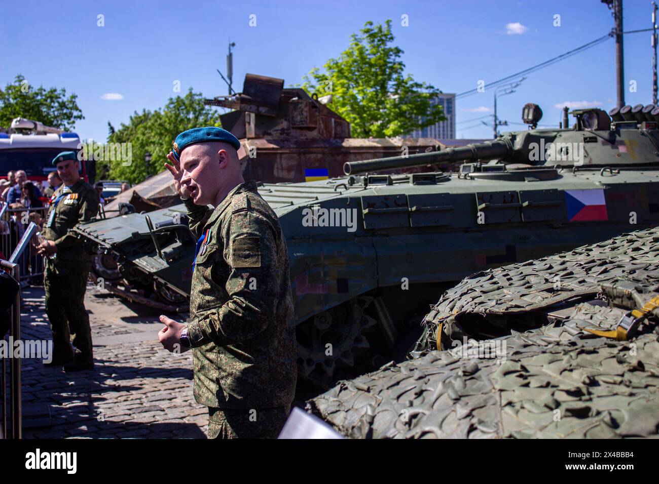 A Russian paratrooper stands next to a line of captured military ...