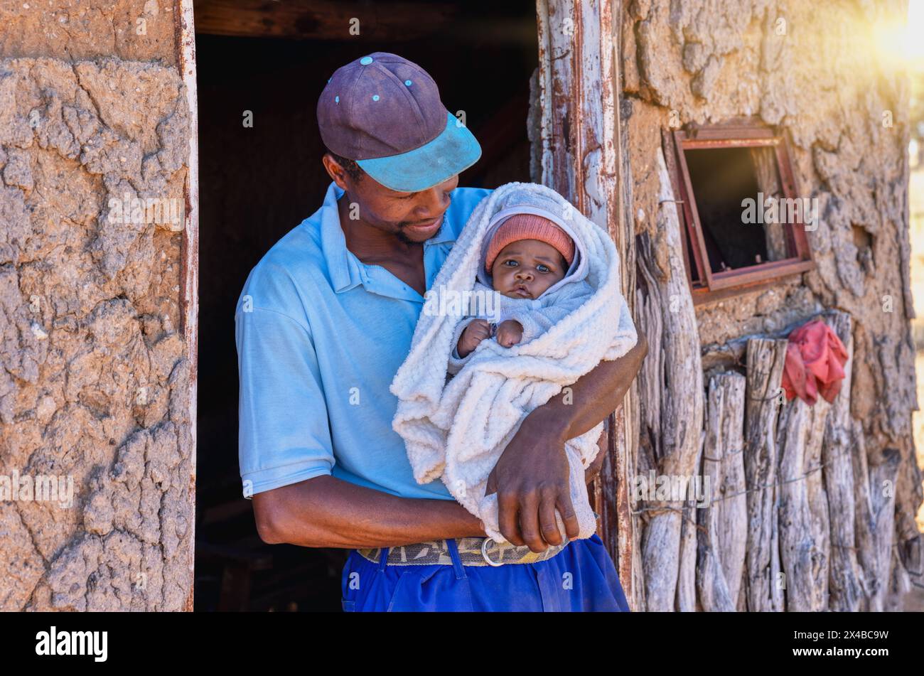 african village, single african father holding the baby standing in ...