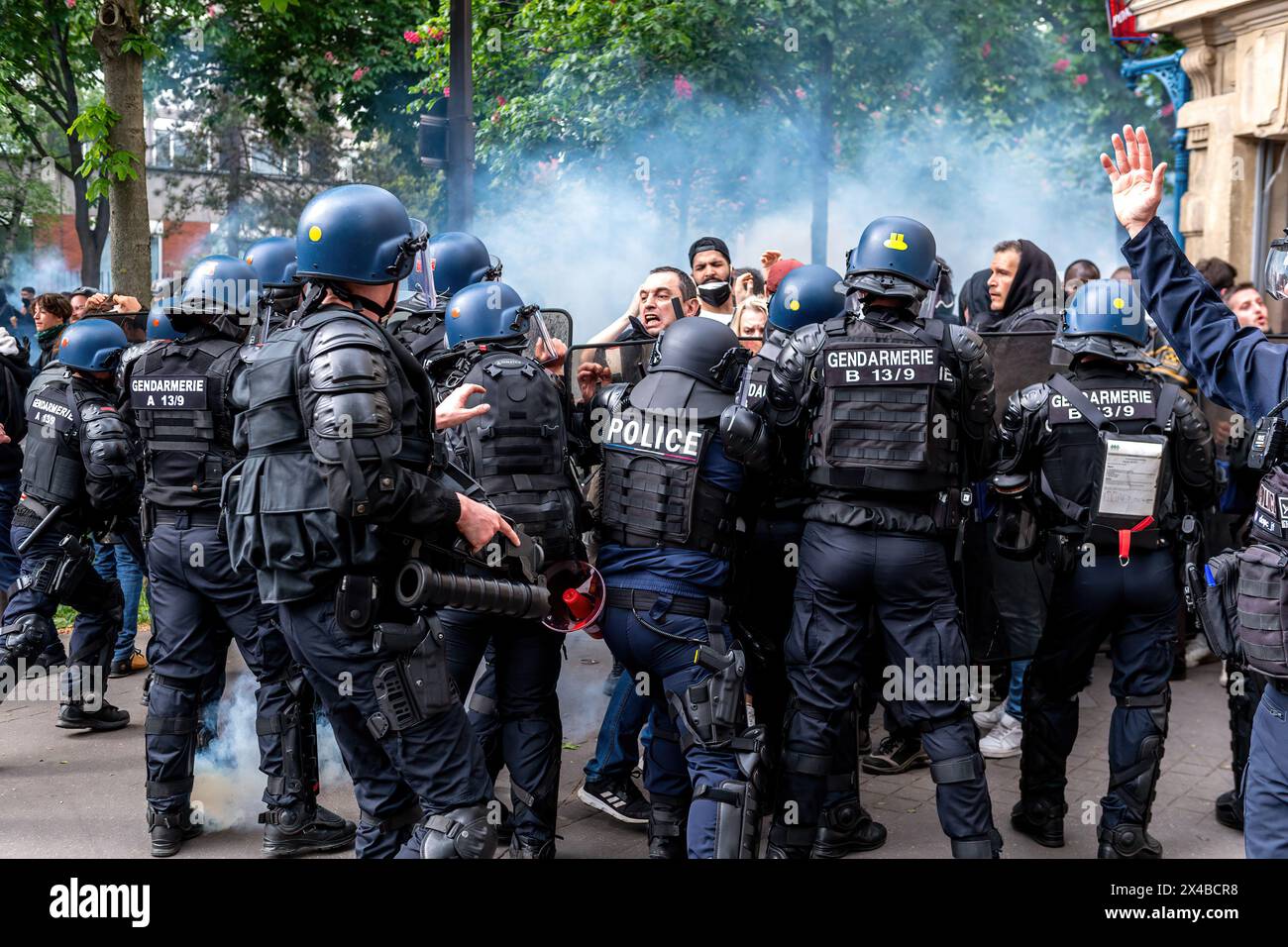 Protester try to push pass riot police to flee tear gas during the ...