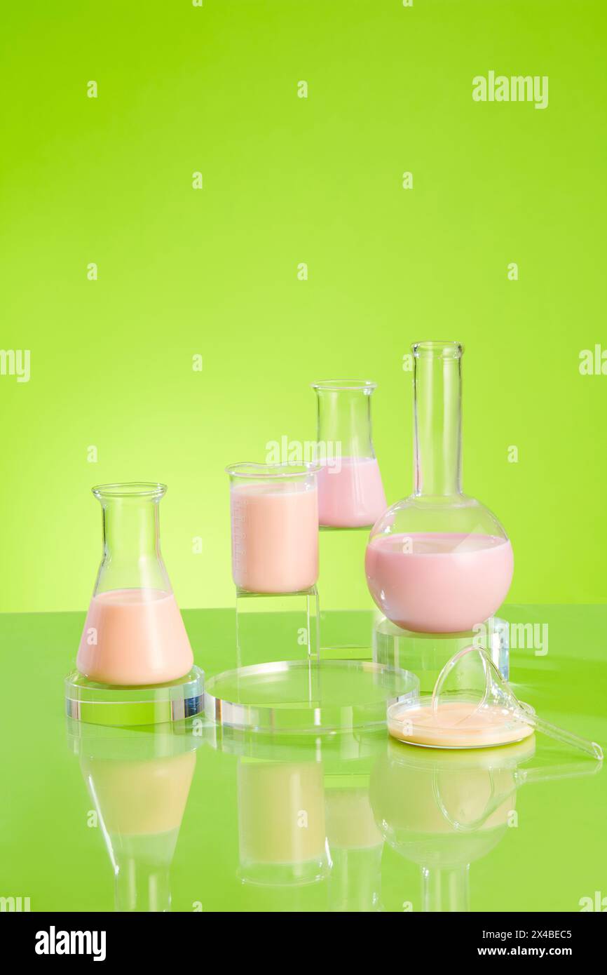 Against the green background, some lab glassware container pink liquid ...