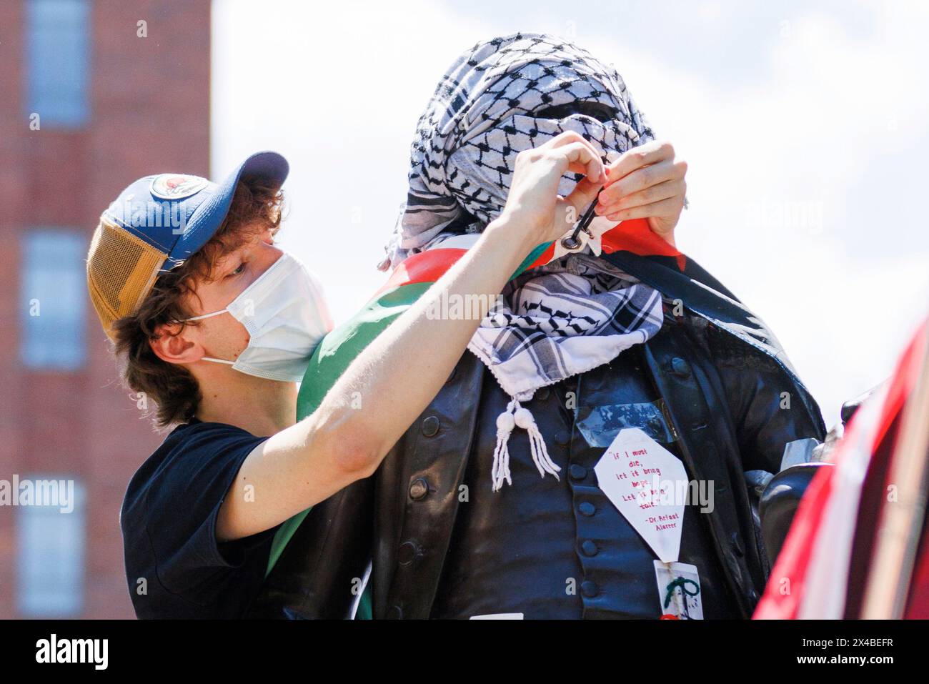 A pro-Palestinian protesters wraps a Palestinian flag on a statue of ...