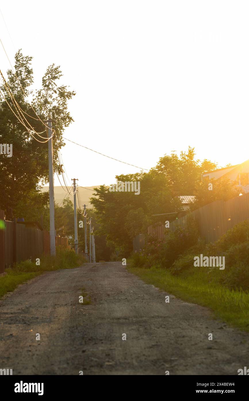 A road from the countryside going into the distance. Brown fence in the ...