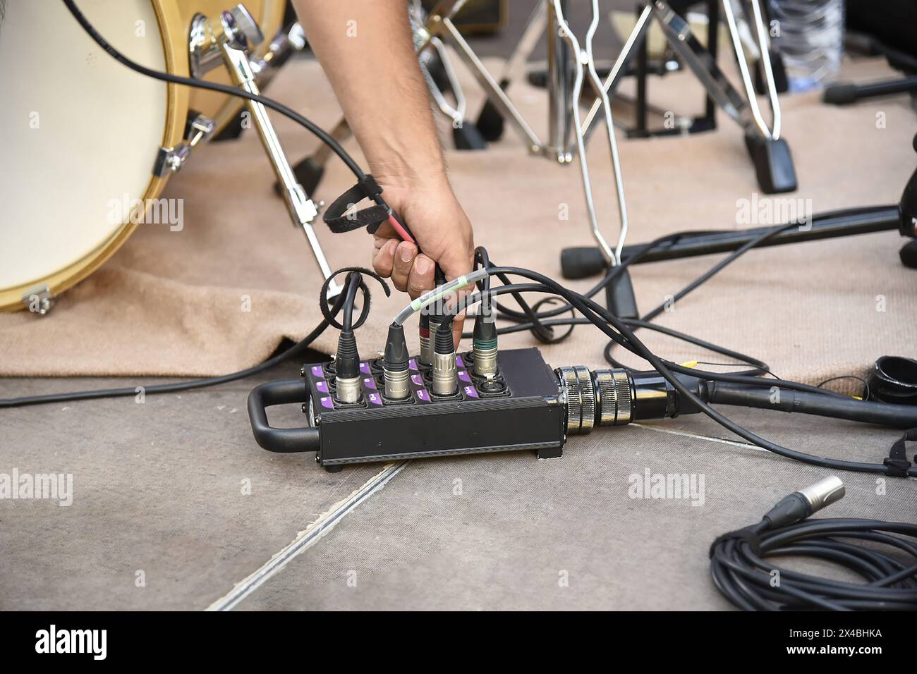 Hand connecting cables to a junction box on a stage, preparation for an ...