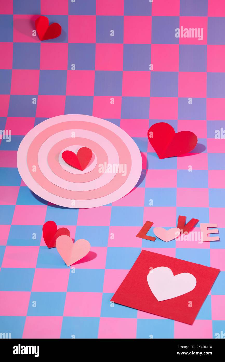 On a color checkered background, paper cut in heart shape, card and ...