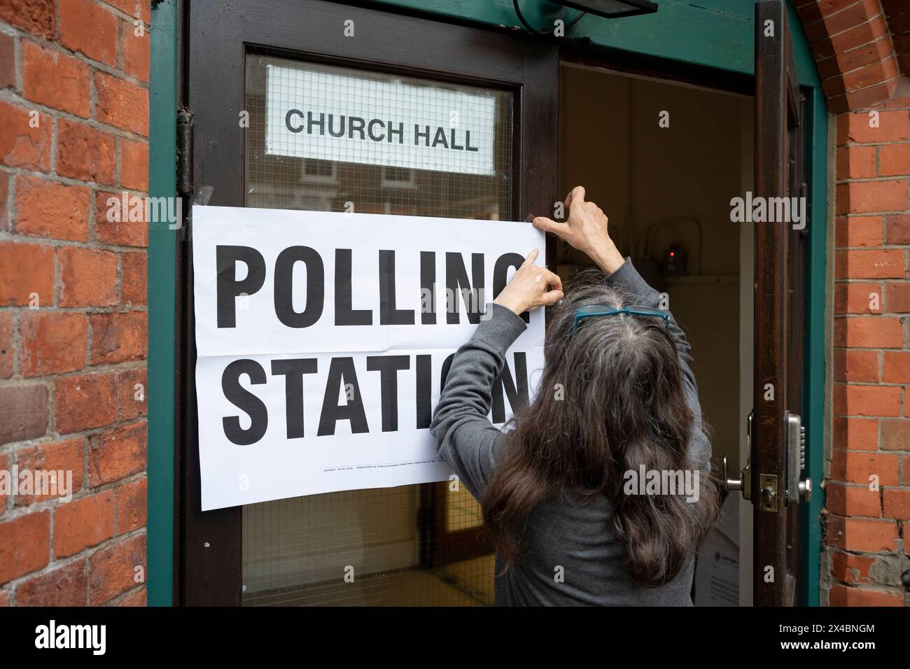 A staff member attaches posters outside the polling station at the ...