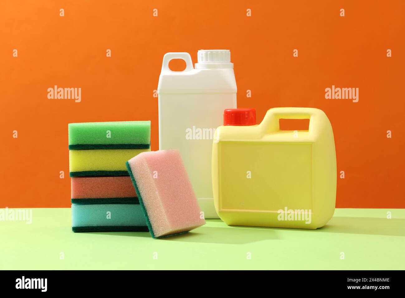 On the orange background and green plain, two detergent canisters blank ...