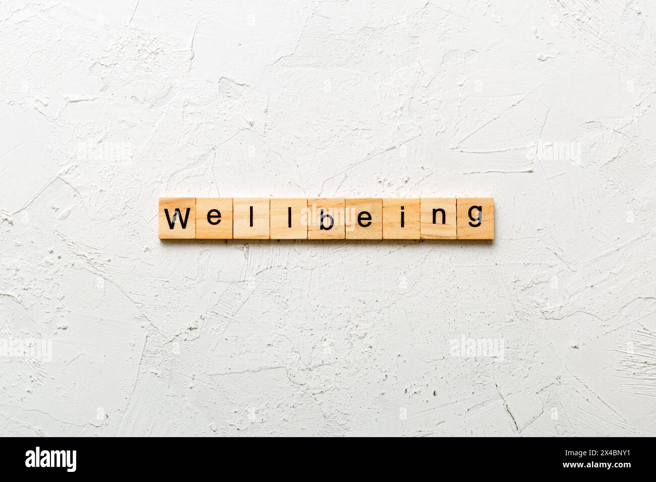 Wellbeing word written on wood block. Wellbeing text on cement table ...