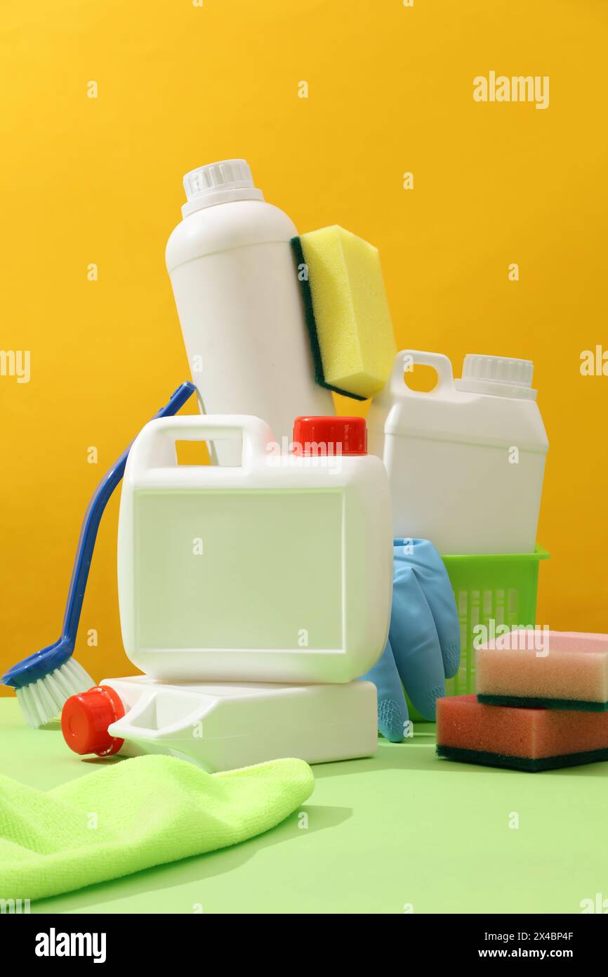 Colorful cleaning products on a plain yellow background. White bottle ...