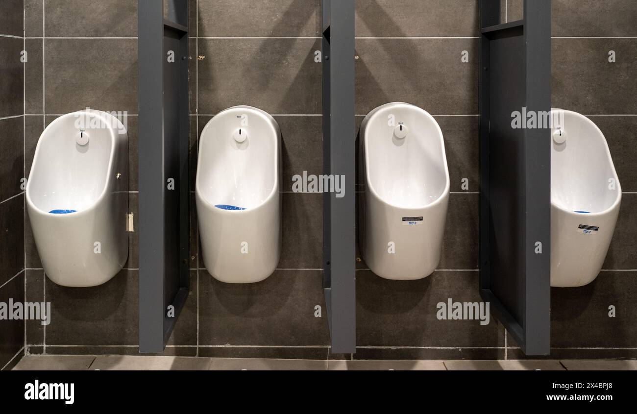 Row of modern white urinals in public restroom Stock Photo - Alamy