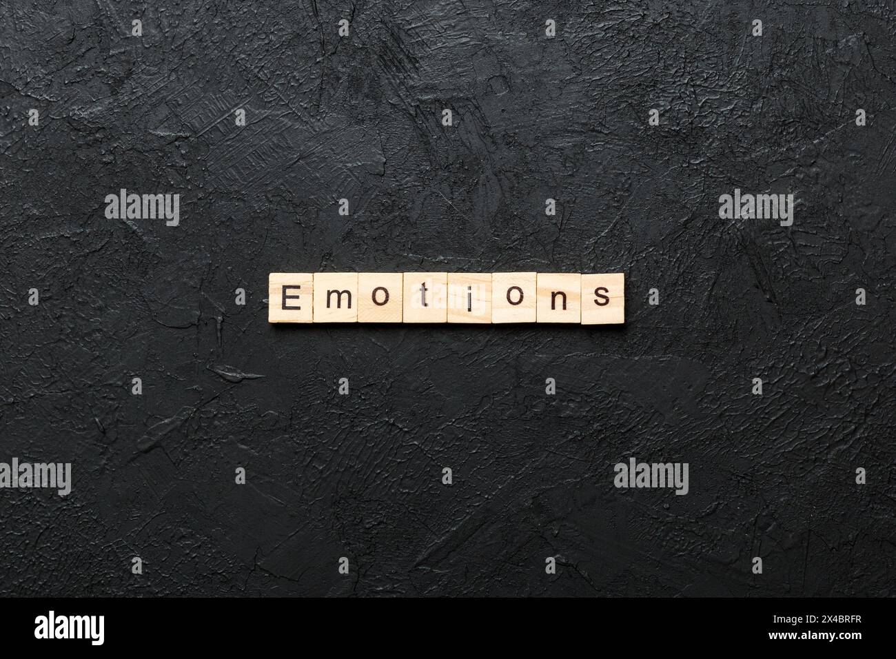EMOTIONS word written on wood block. EMOTIONS text on cement table for ...