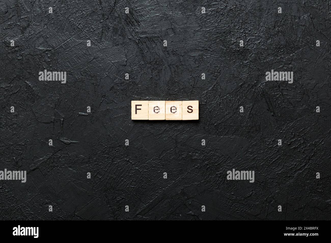 Fees word written on wood block. Fees text on cement table for your ...