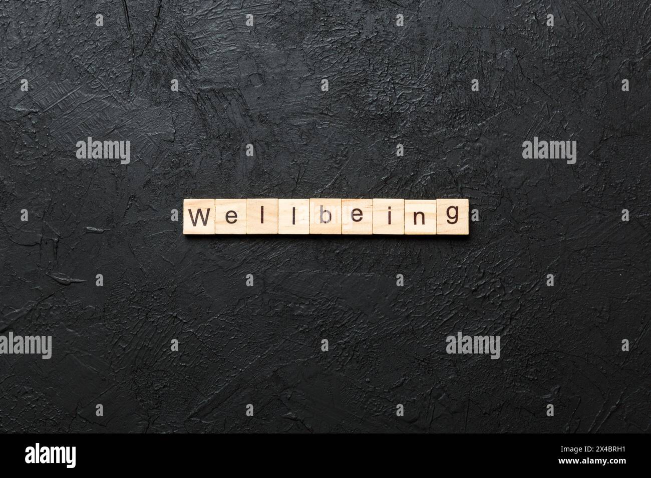 Wellbeing word written on wood block. Wellbeing text on cement table ...