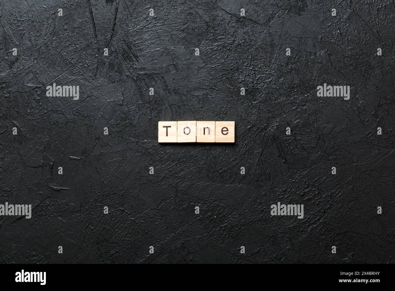 tone word written on wood block. tone text on cement table for your ...