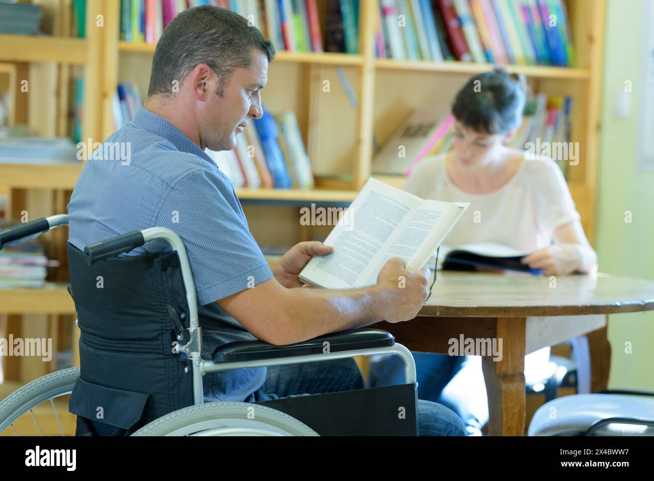 student in wheelchair reading his book Stock Photo - Alamy
