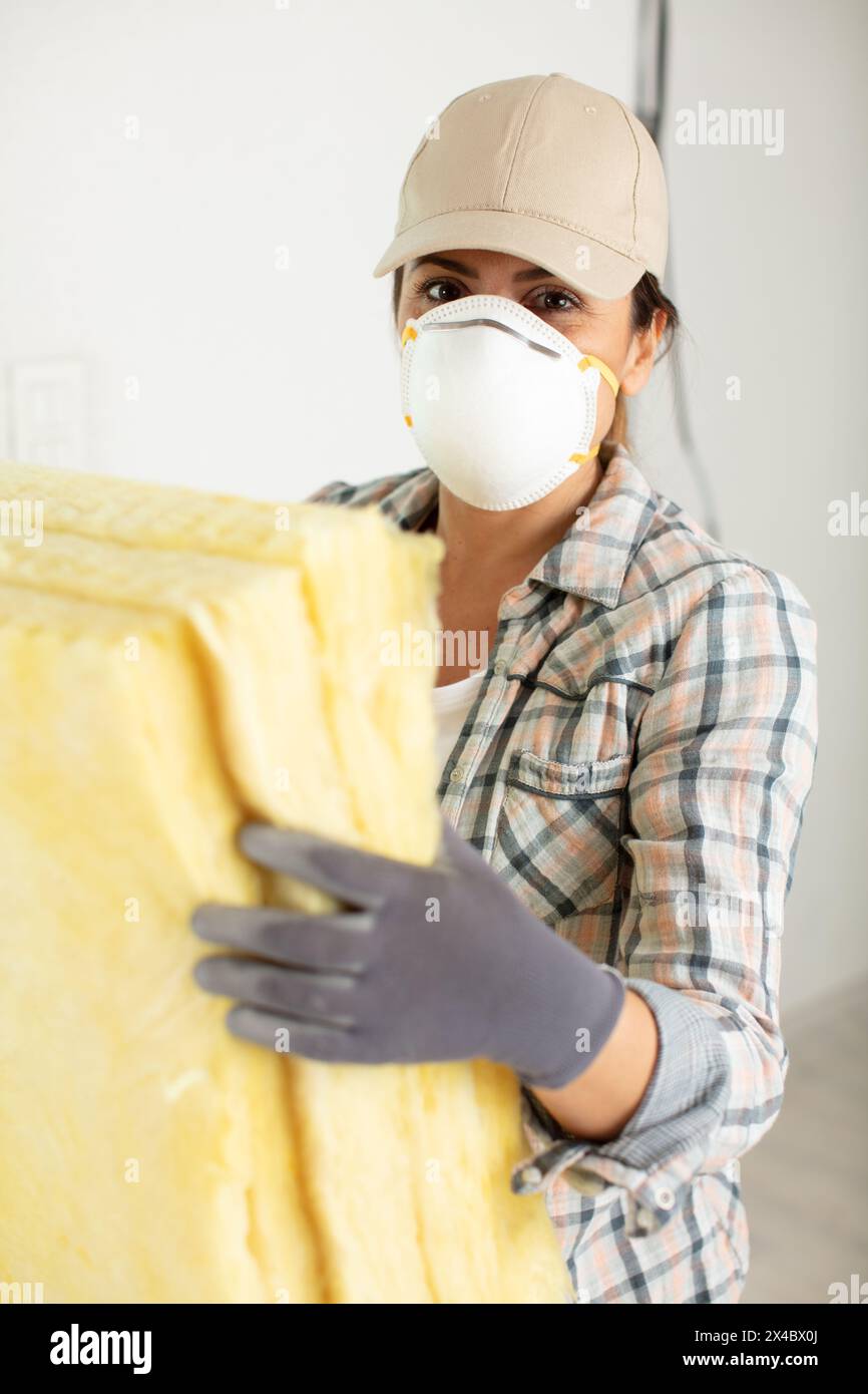 female worker at a indoors wall insulation works Stock Photo - Alamy