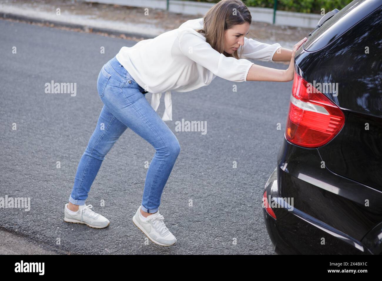 woman pushing a broken down car Stock Photo - Alamy