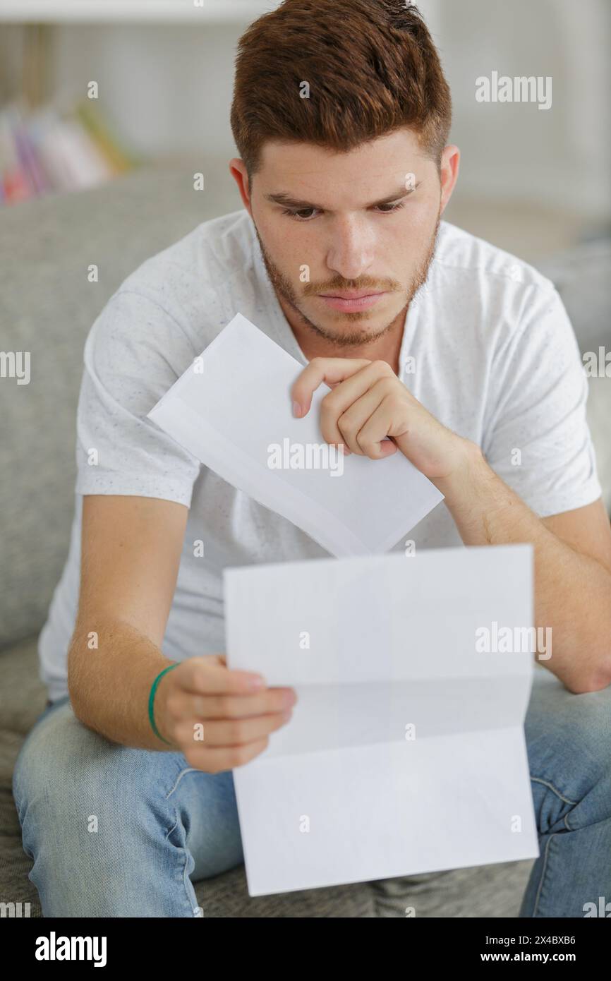 young man at home reading letter Stock Photo - Alamy