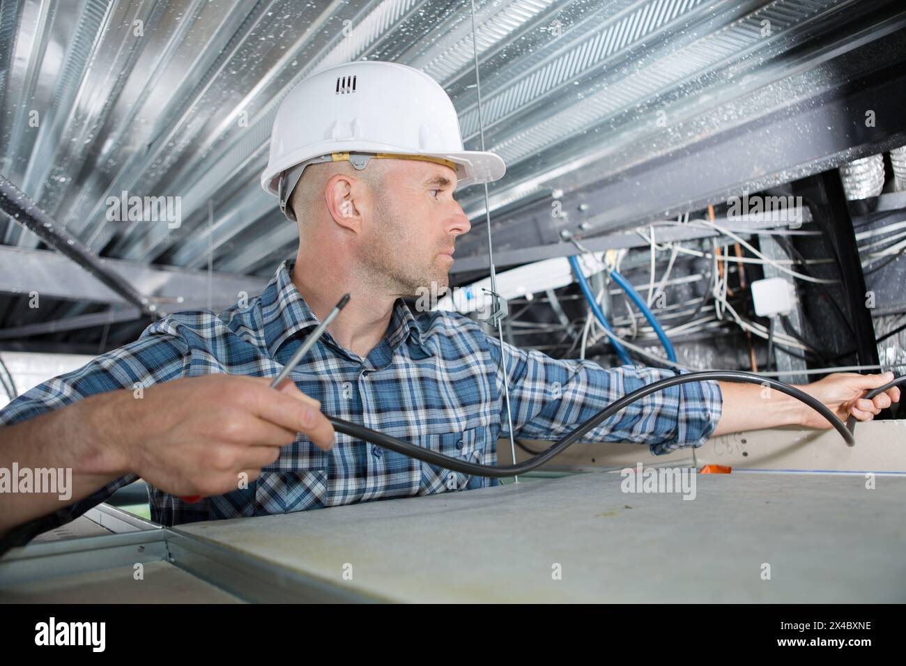electrical worker wiring in ceiling Stock Photo - Alamy