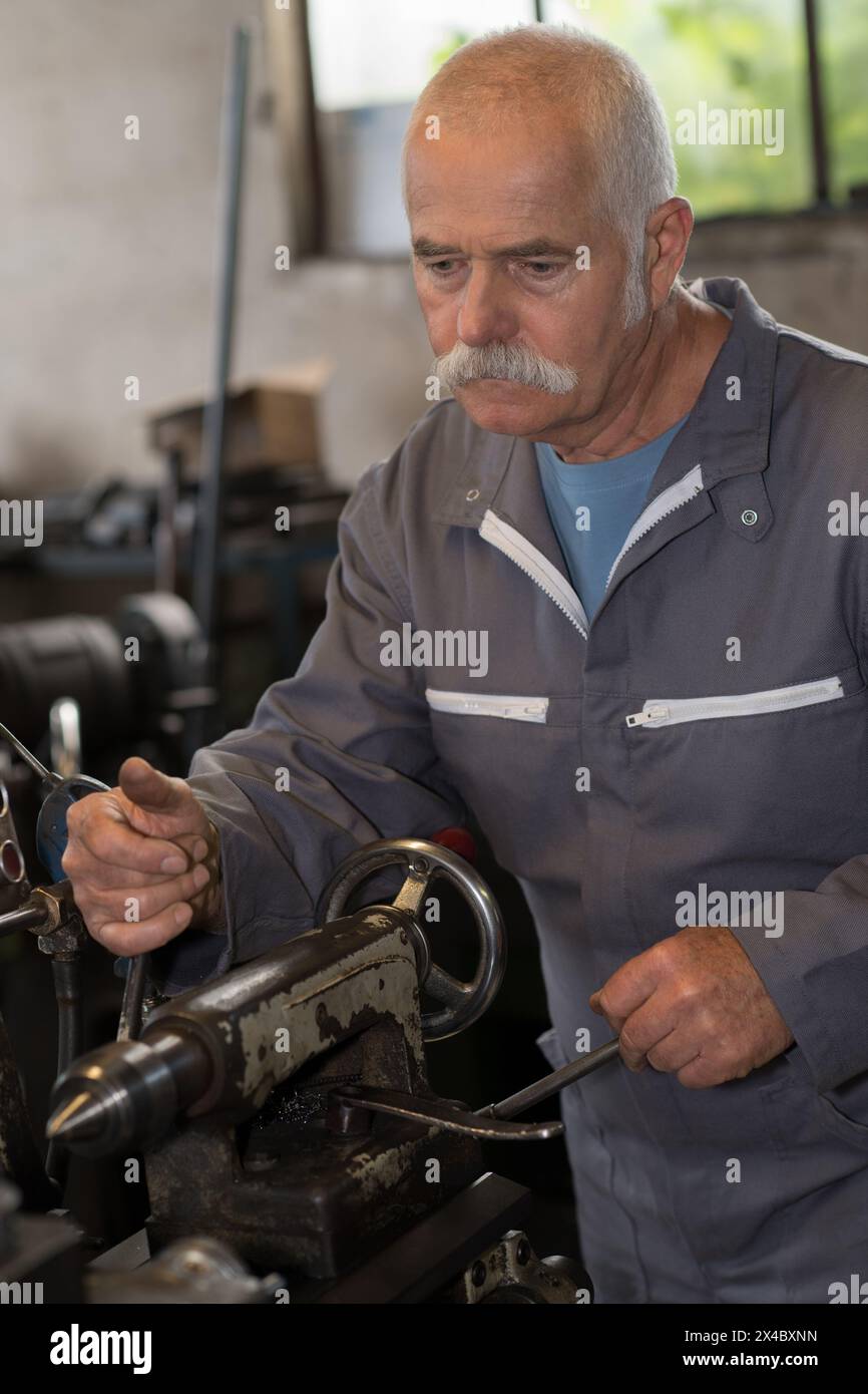 senior mechanic repairing industrial sewing machine Stock Photo - Alamy