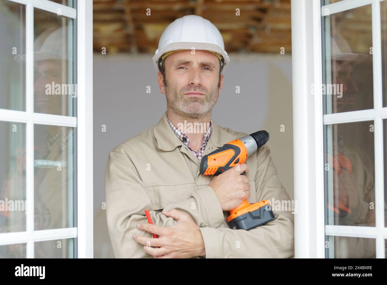 male builder drilling holes in wall at construction site Stock Photo ...