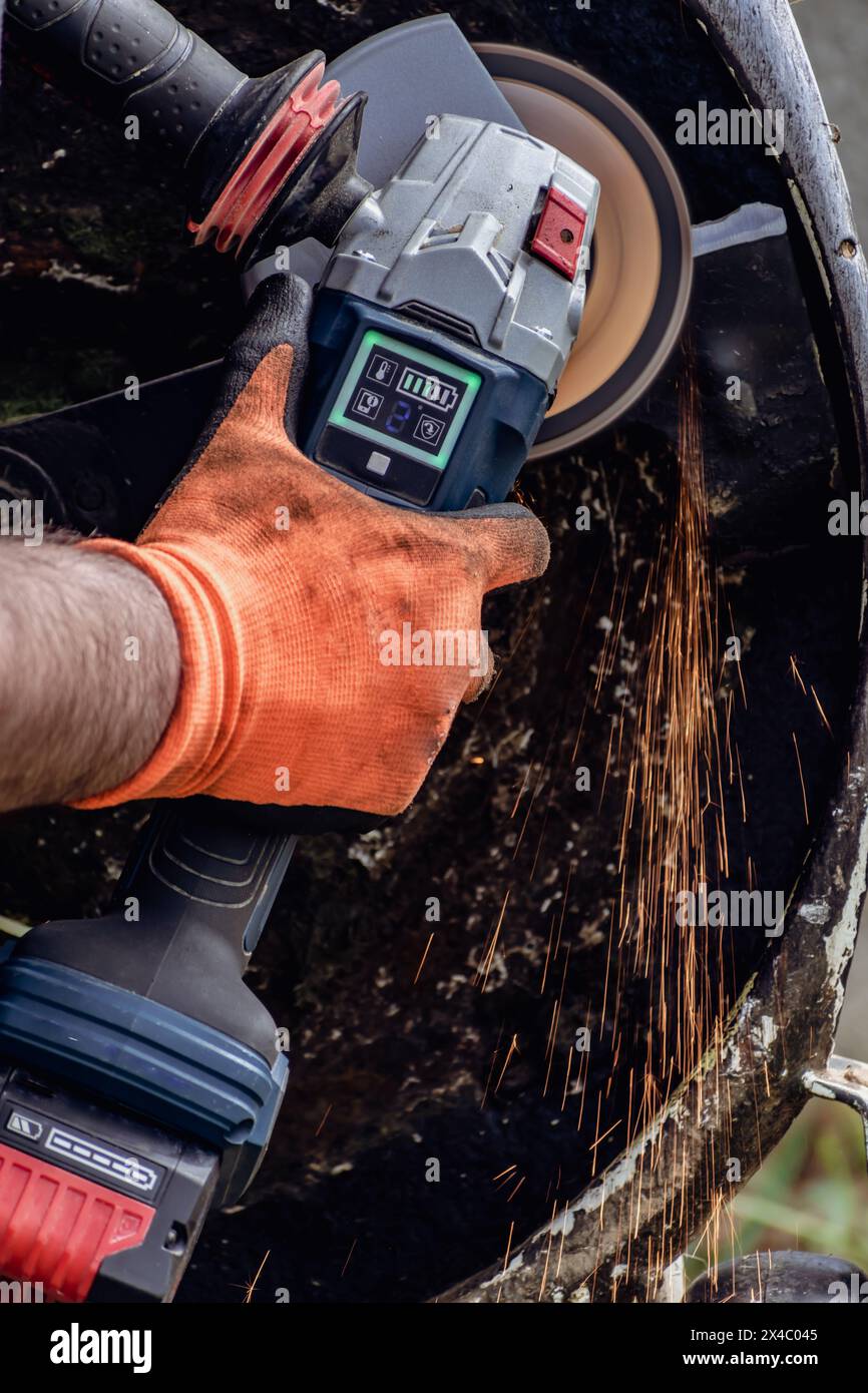 Man using portable grinder with sparkles Stock Photo - Alamy