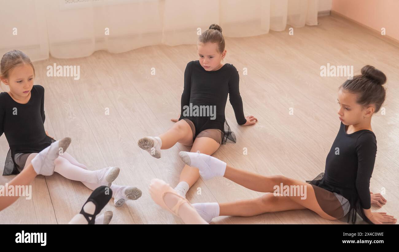 Little girls sit in a circle and do stretching at a ballet school Stock ...