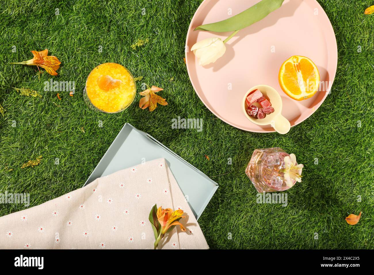 Summer picnic on the grass with pink dish container fruits and jam ...