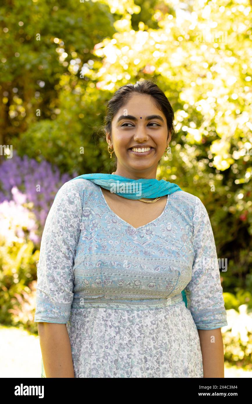 An Indian young woman wearing blue traditional outfit, smiling outdoors ...